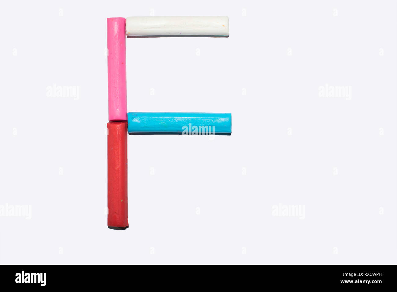 Letter F - Multi-colored clay sticks forming the letter F on a white ...