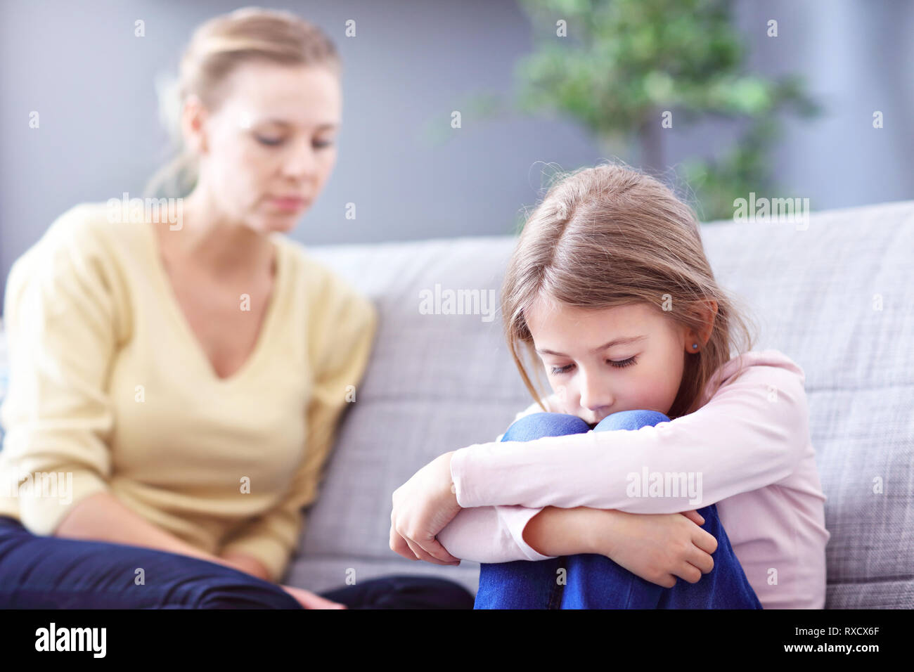 Sad little girl and her mom at home Stock Photo - Alamy