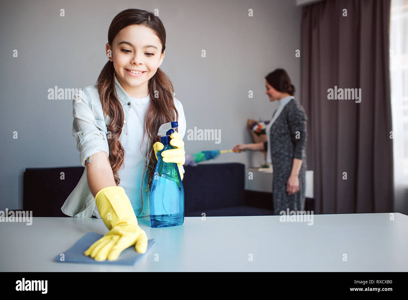Beautiful brunette caucasian mother and daughter cleaning together in ...