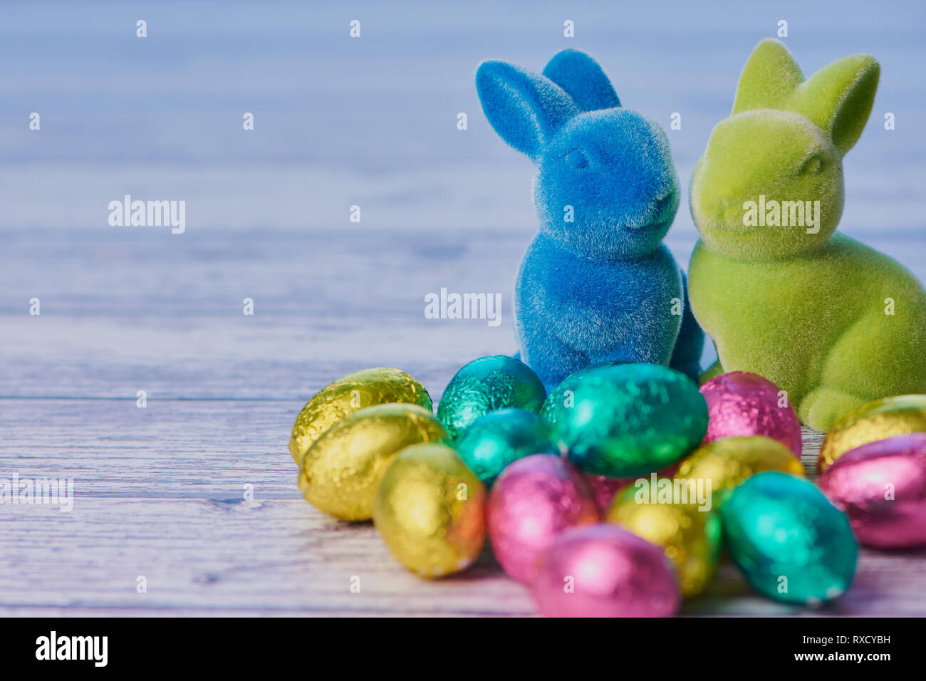blue easter bunny and green easter bunny with wrapped chocolate eggs ...