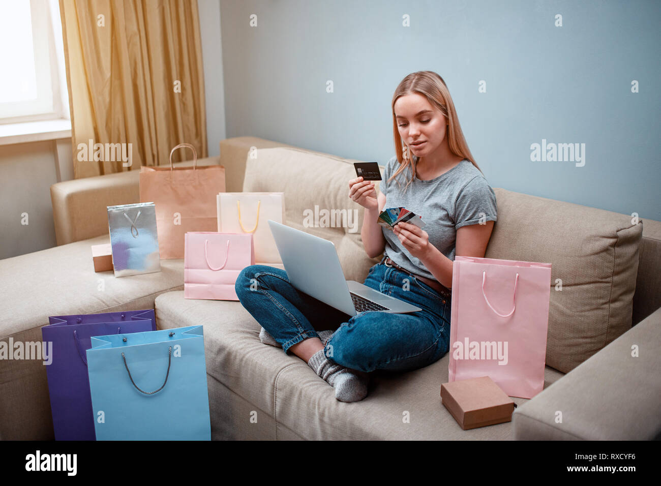 Online shopping at home. Young happy shopper with laptop is choosing ...