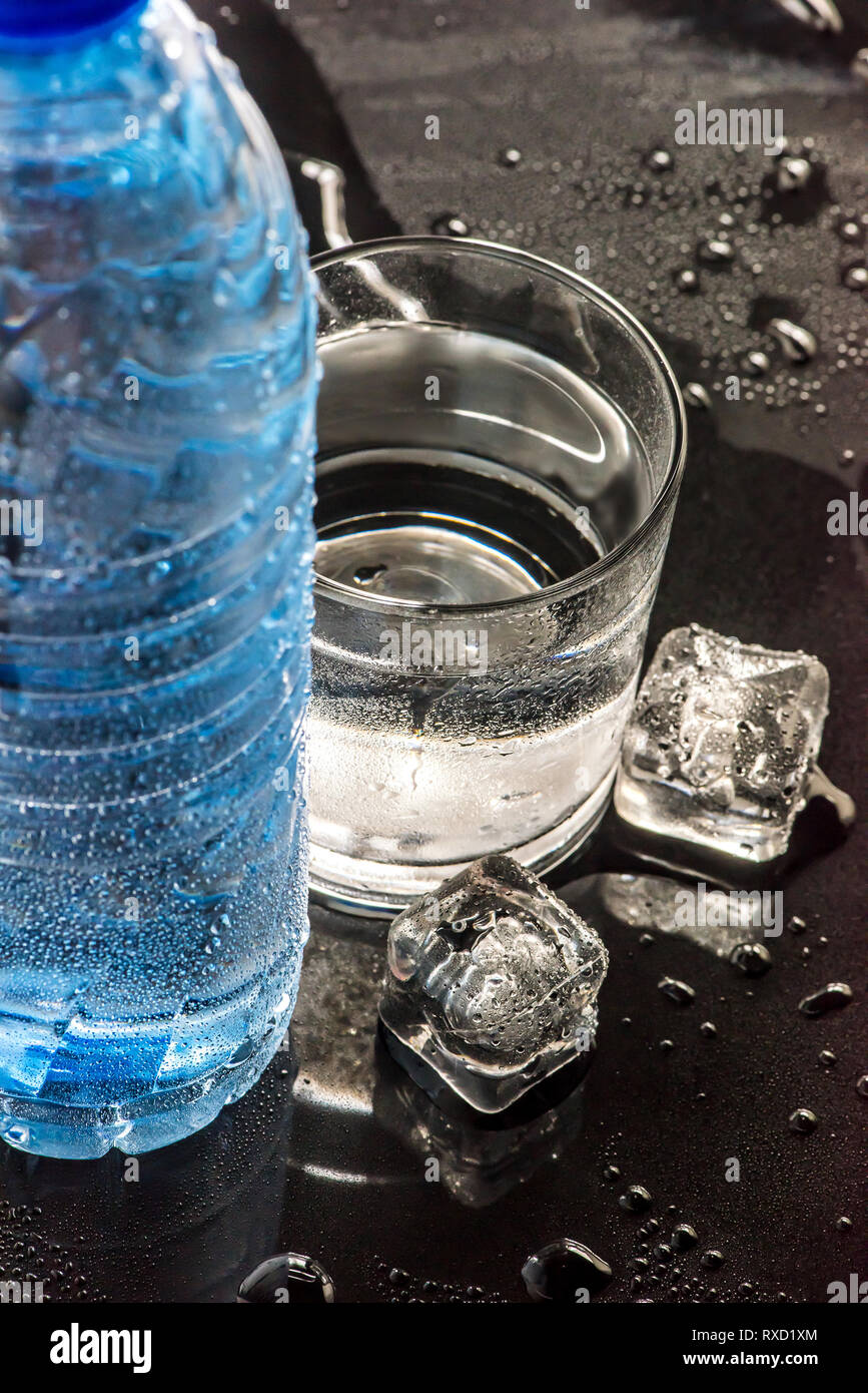 Sweaty Chilled Bottled water, ice cubes and glass Stock Photo - Alamy