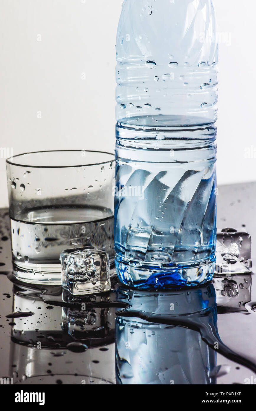 Sweaty Chilled Bottled water, ice cubes and glass Stock Photo - Alamy