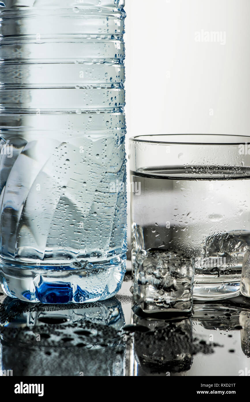 Sweaty Chilled Bottled water, ice cubes and glass Stock Photo - Alamy