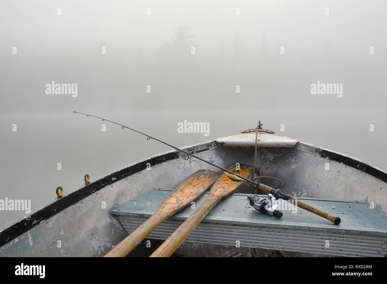 lake fishing aboard a small boat, looking at the thick fog of a cold ...