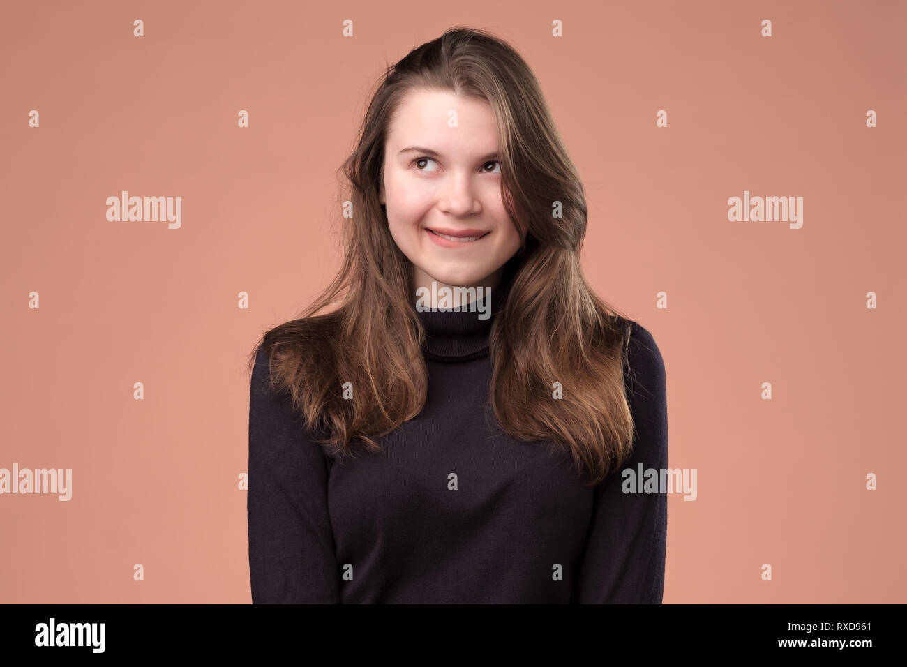 Studio portrait of a cunning girl looking aside. Creating a tricky plan ...