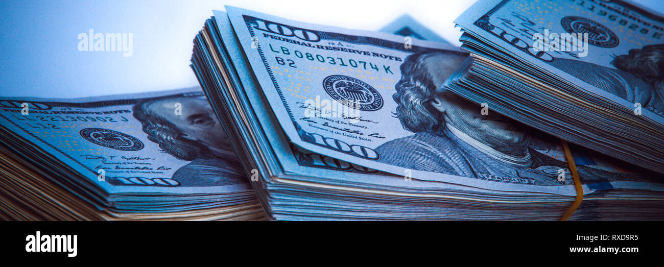 Banknotes of dollars in packs. Dark blue light Stock Photo - Alamy