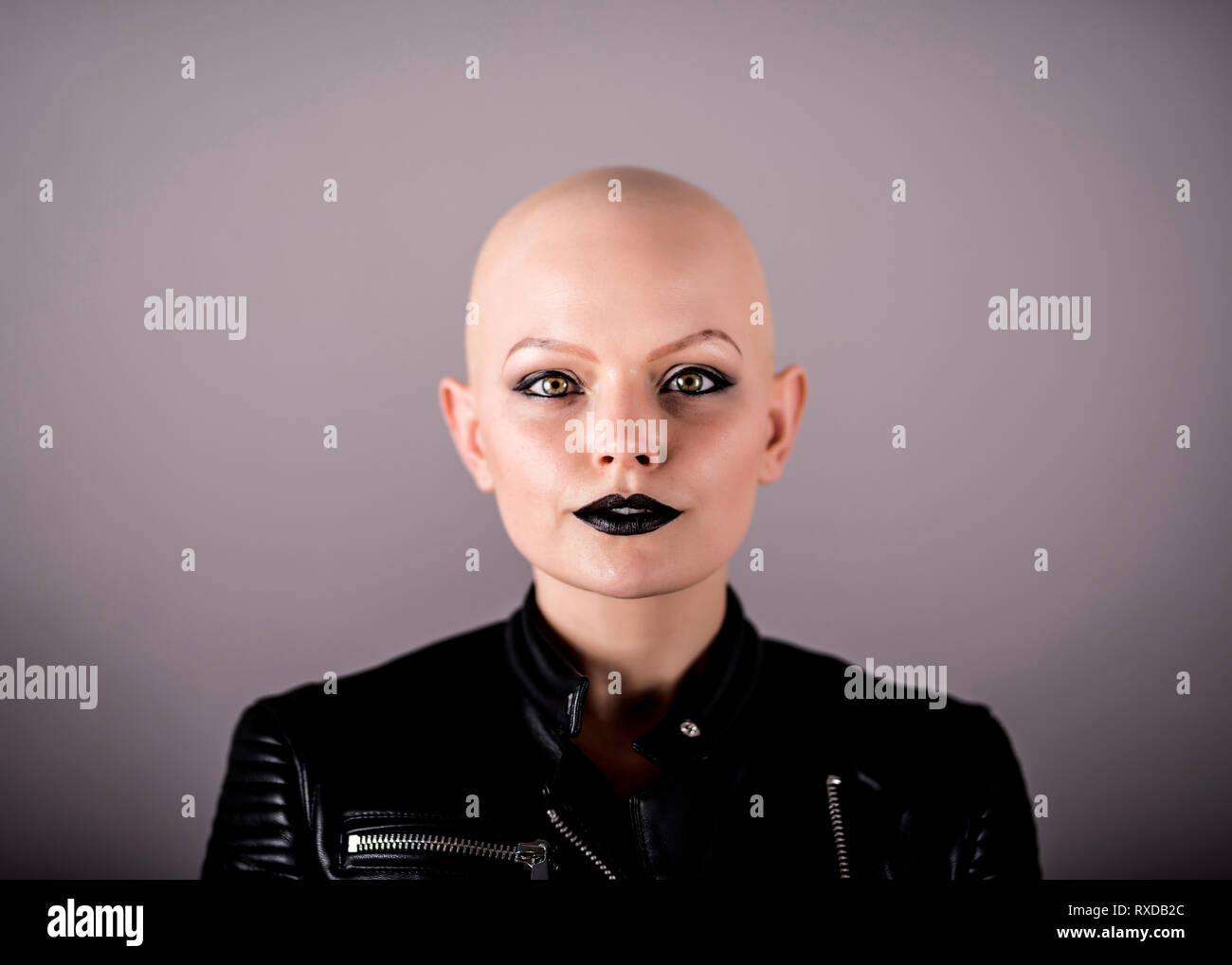 Emotive photo of a beautiful bald woman while standing in the studio ...
