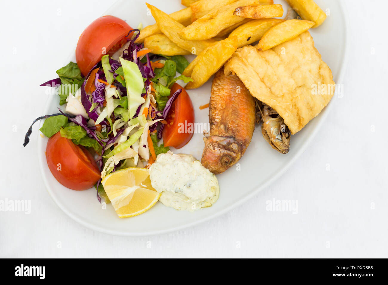 Mix fried fish platter served with fries, salad and mayo sauce ...