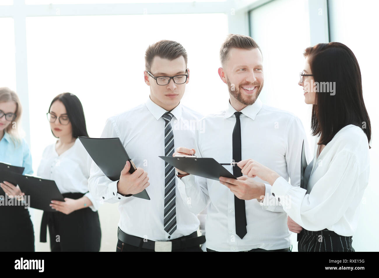 employees discussing business documents in the office Stock Photo - Alamy