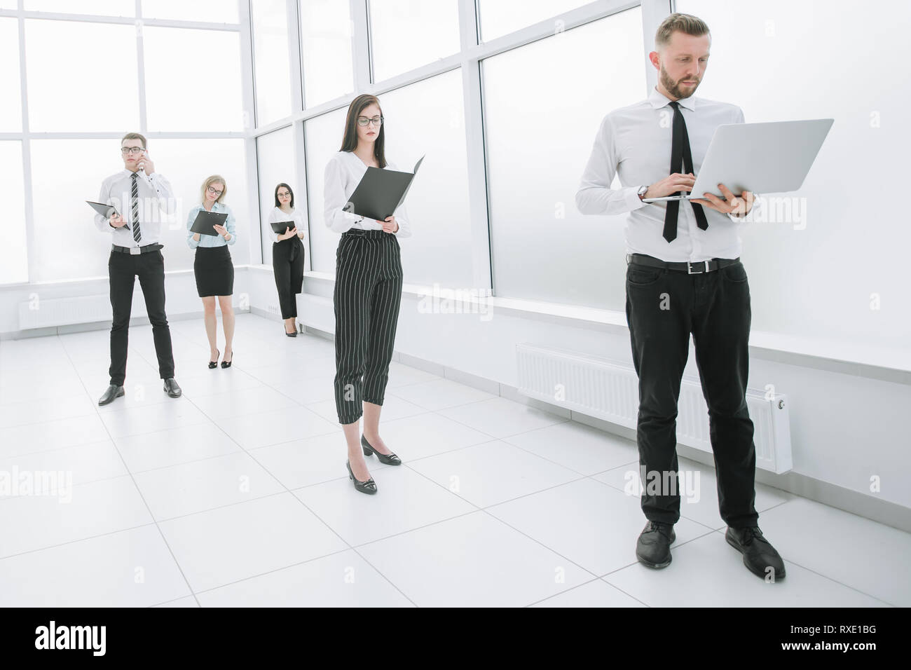 Executive employees of the company standing in the office lobby Stock ...