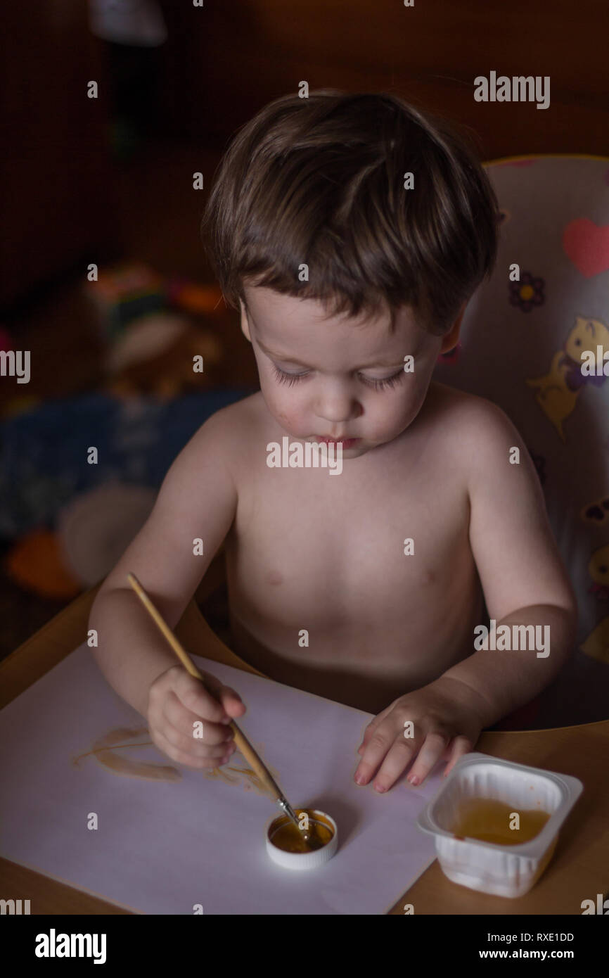 boy paints on paper. children's activities. Hobby - drawing. little boy ...
