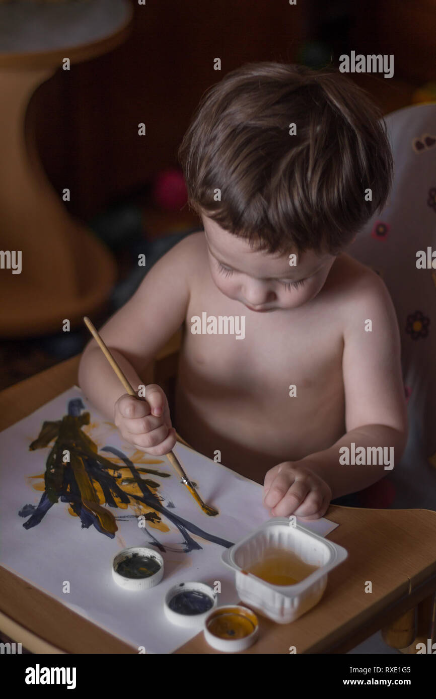 boy paints on paper. children's activities. Hobby - drawing. little boy ...