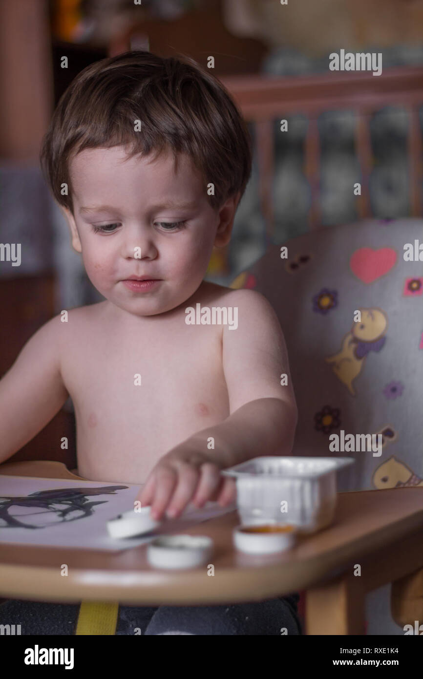 boy paints on paper. children's activities. Hobby - drawing. little boy ...