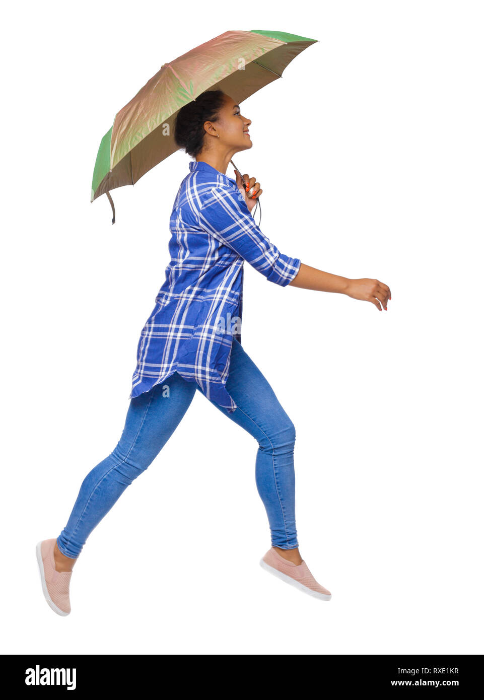 Side view of a woman balancing with an umbrella. girl jumps over a ...