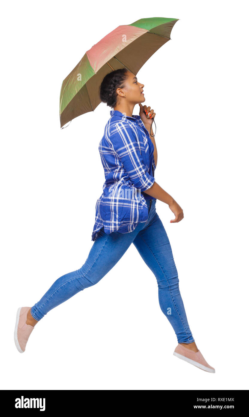 Side view of a woman balancing with an umbrella. girl jumps over a ...
