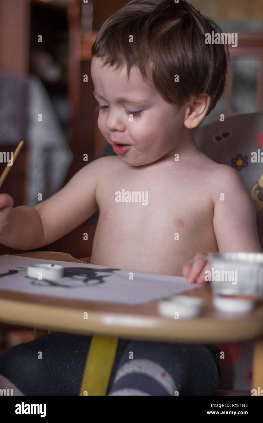 boy paints on paper. children's activities. Hobby - drawing. little boy ...