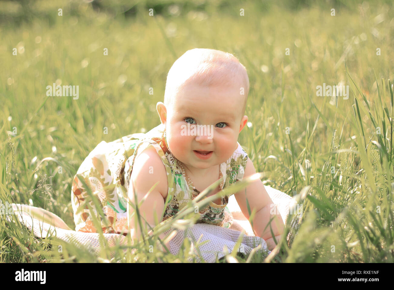 pretty baby girl on the lawn in the spring day Stock Photo - Alamy