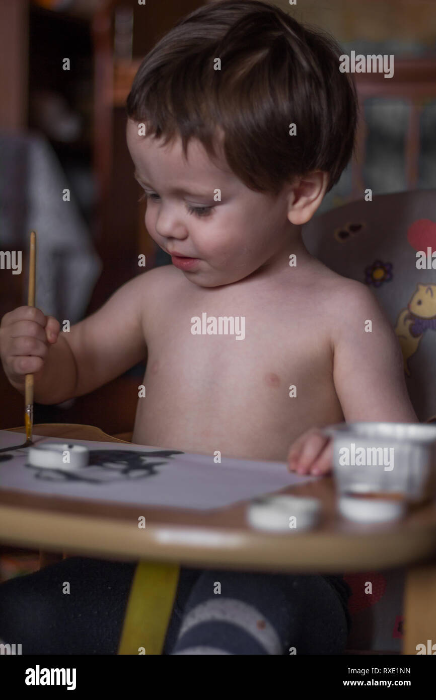 boy paints on paper. children's activities. Hobby - drawing. little boy ...