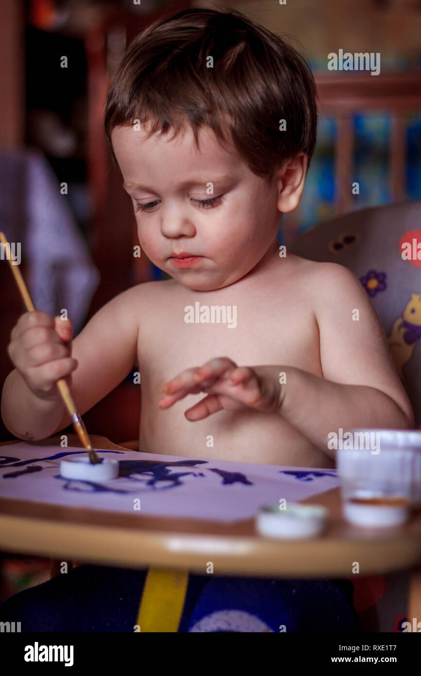 boy paints on paper. children's activities. Hobby - drawing. little boy ...