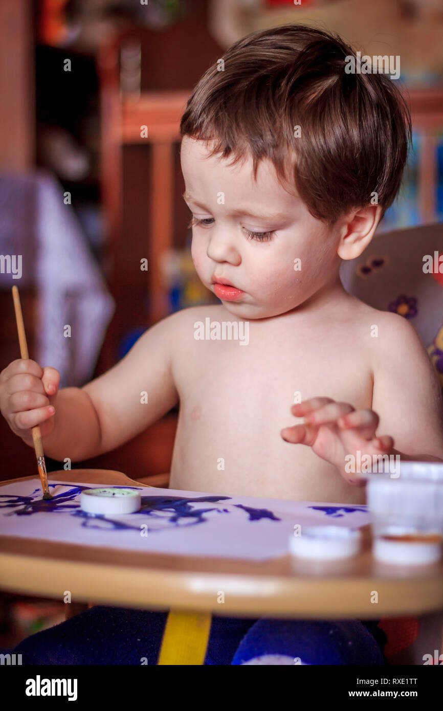 boy paints on paper. children's activities. Hobby - drawing. little boy ...