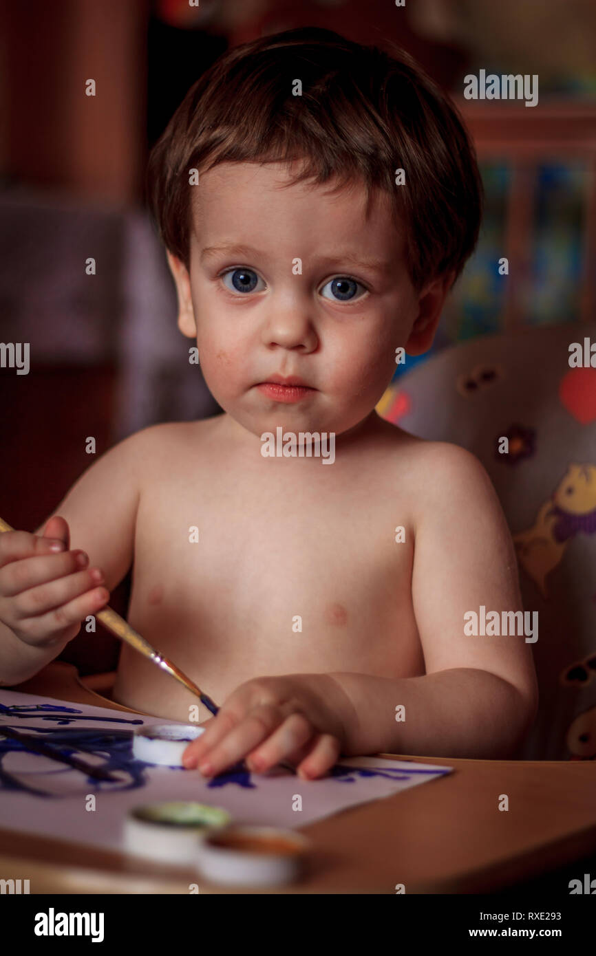 boy paints on paper. children's activities. Hobby - drawing. little boy ...