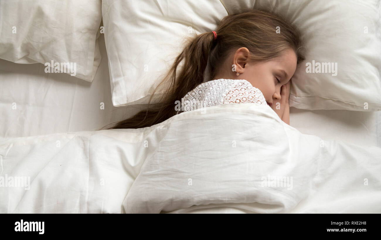 Adorable little girl sleeping alone in comfortable bed, top view Stock ...
