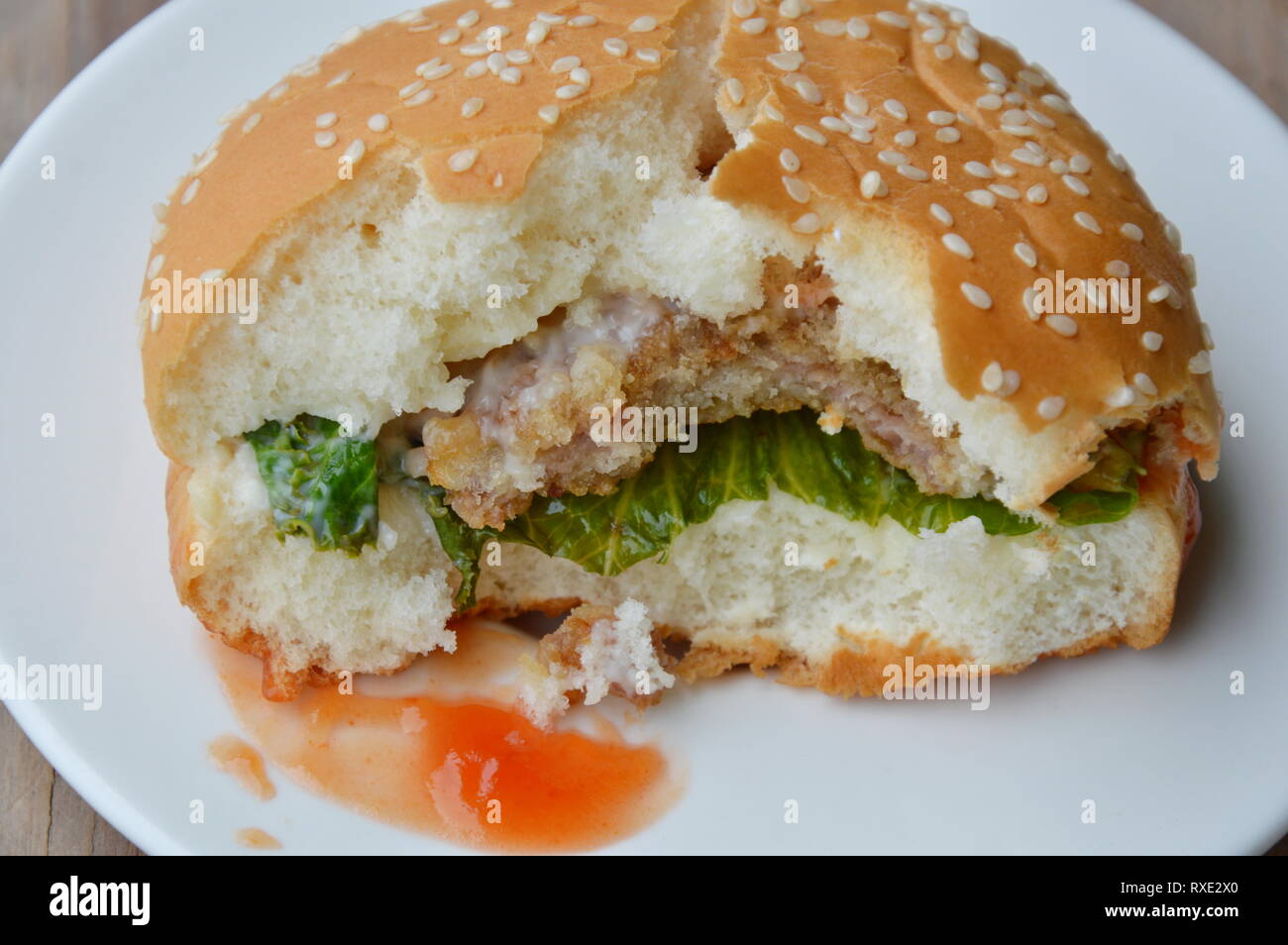 pork hamburger dressing ketchup biting on dish Stock Photo - Alamy