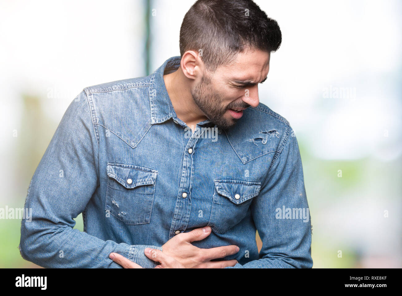 Young handsome man over isolated background with hand on stomach ...