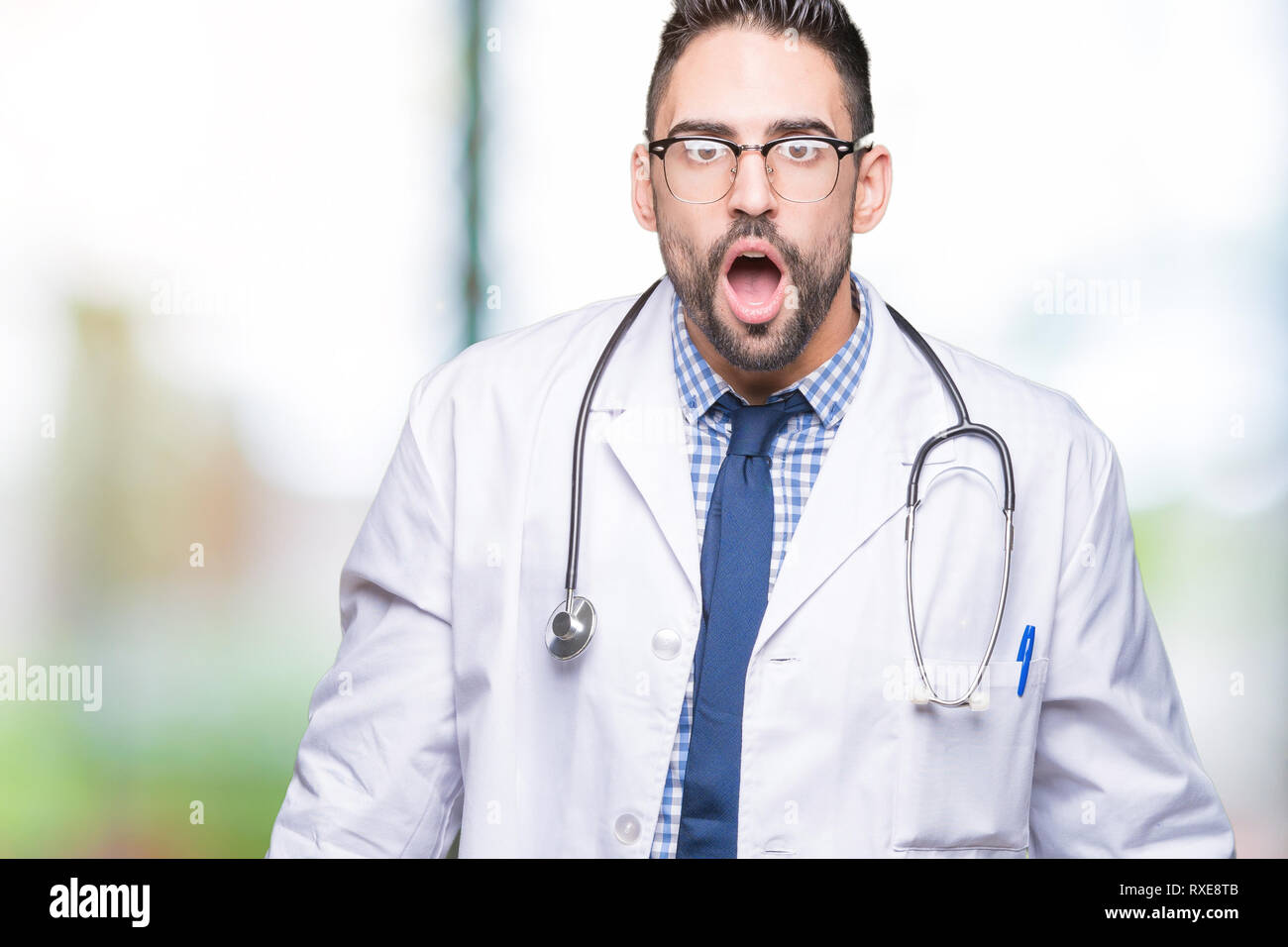 Handsome young doctor man over isolated background In shock face ...