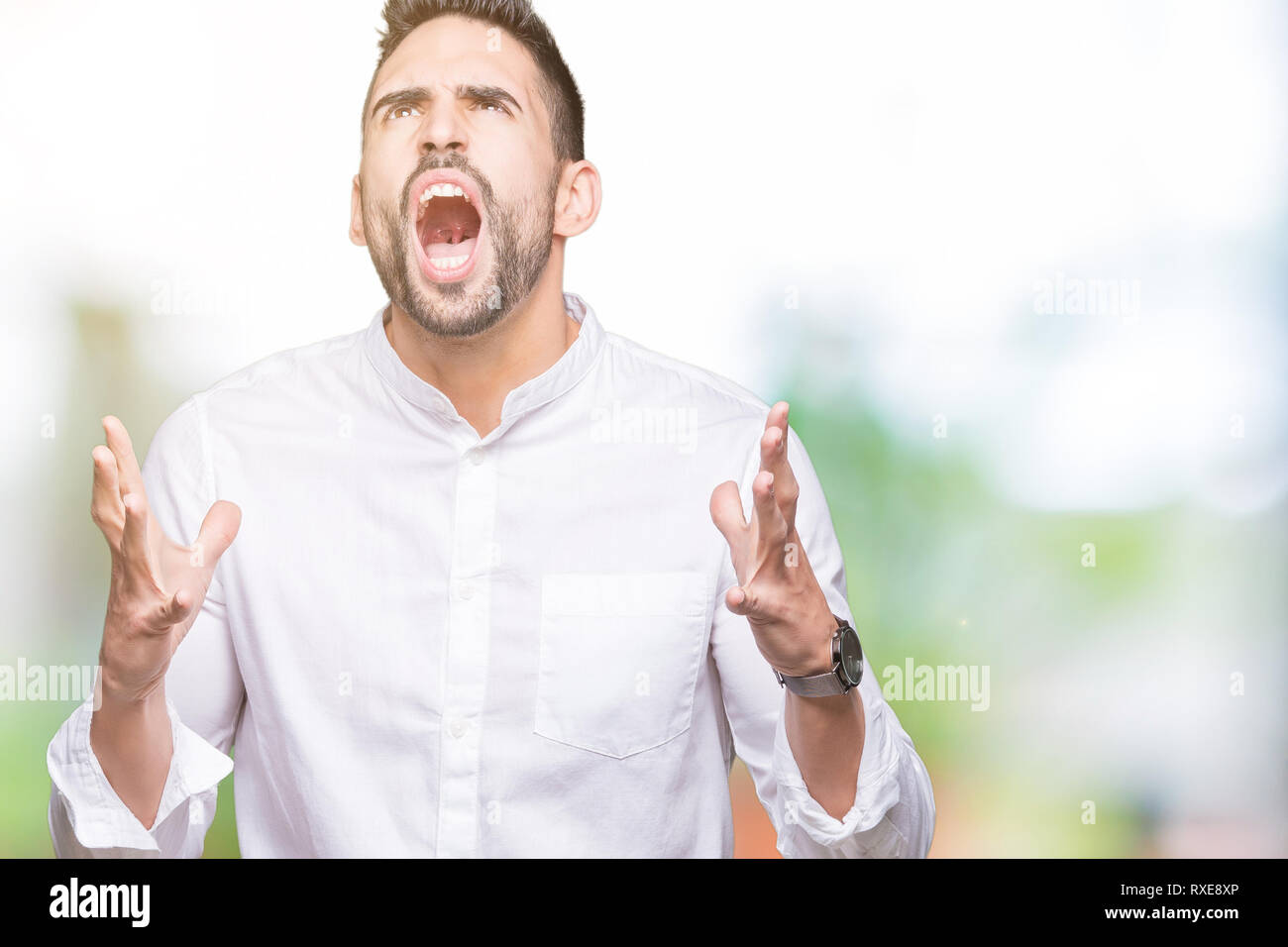 Young business man over isolated background crazy and mad shouting and ...