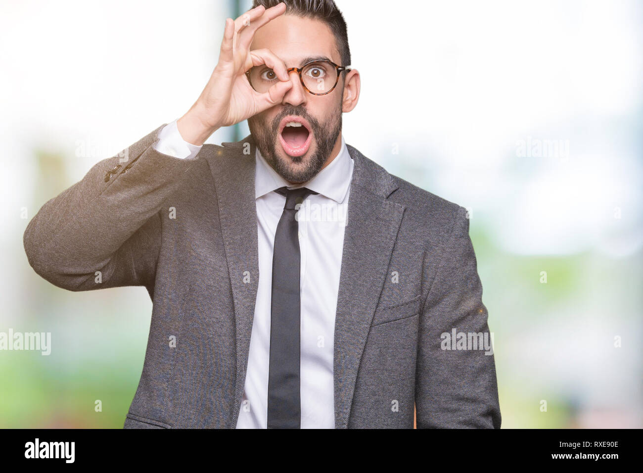 Young handsome business man over isolated background doing ok gesture ...