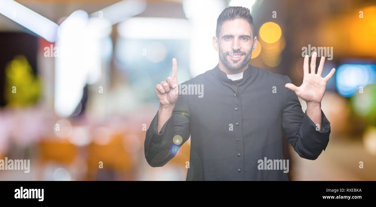 Young Christian priest over isolated background showing and pointing up ...