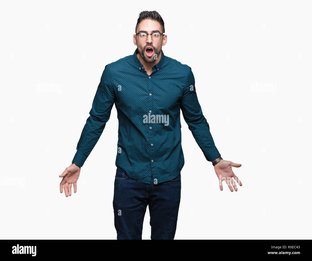 Young handsome business man wearing glasses over isolated background afraid and shocked with ...