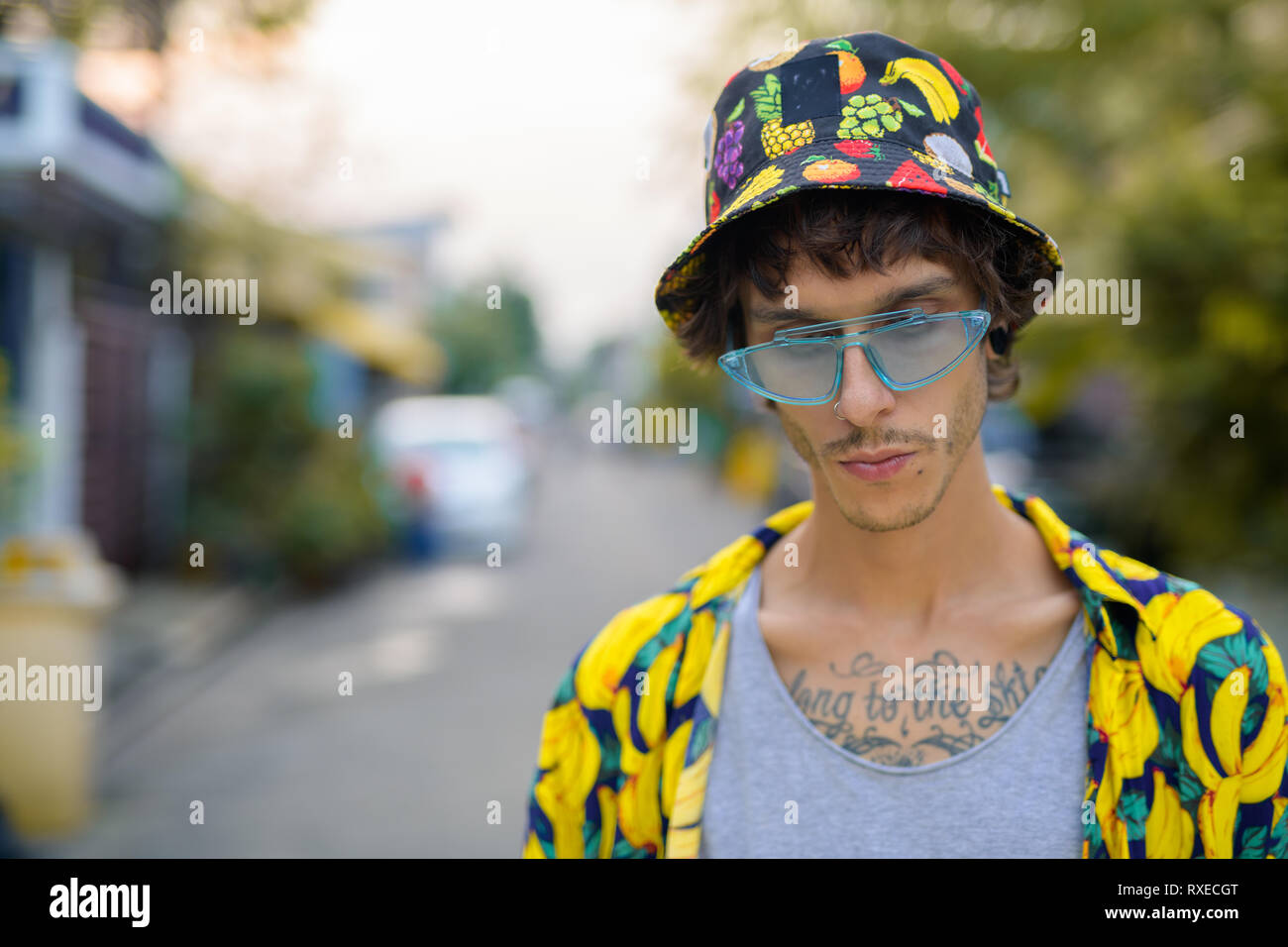 Face of young rebellious man thinking while looking down outdoors Stock ...