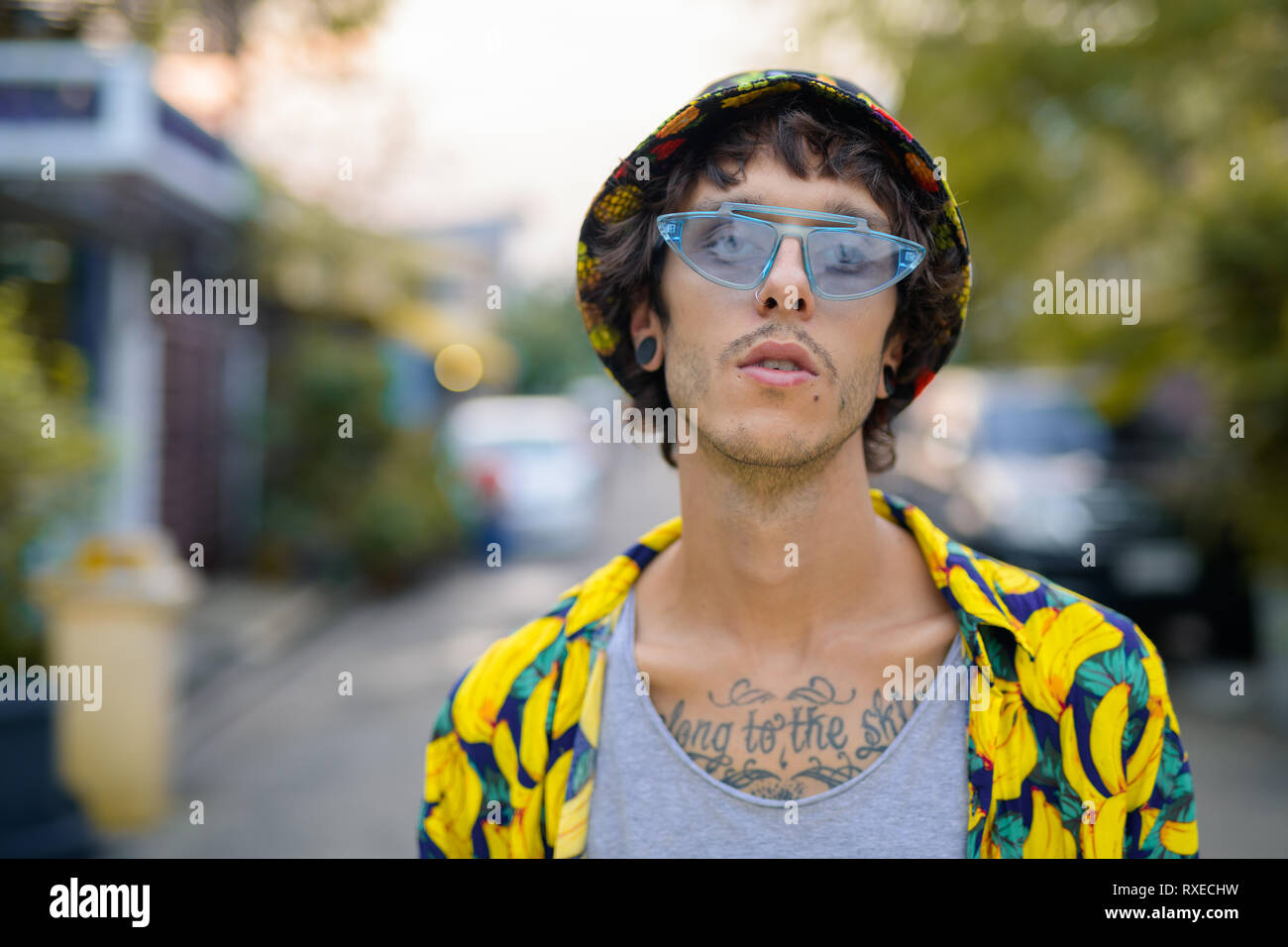 Face of young rebellious man with eyeglasses outdoors Stock Photo - Alamy