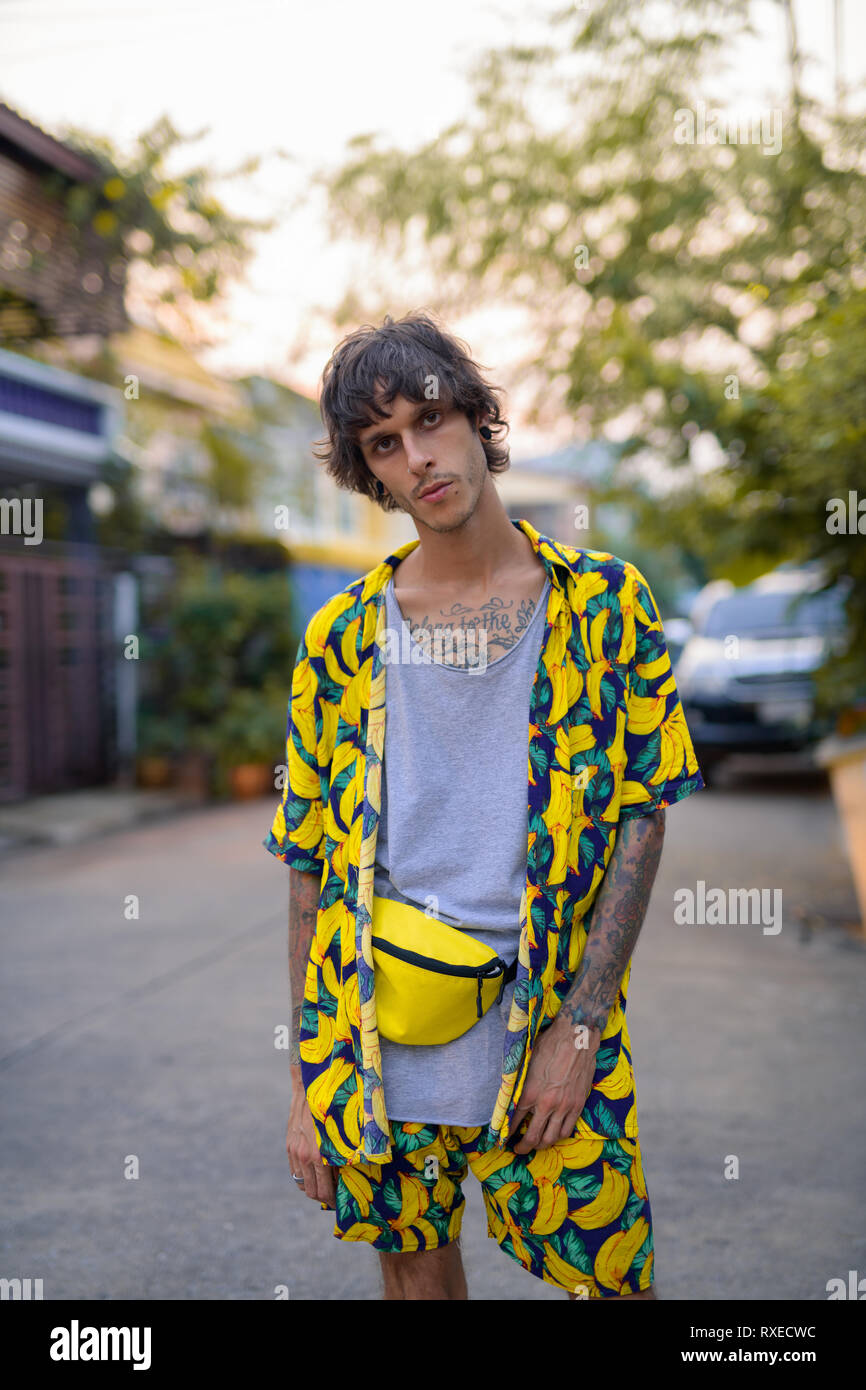 Portrait of young rebellious man standing in the streets outdoors Stock ...