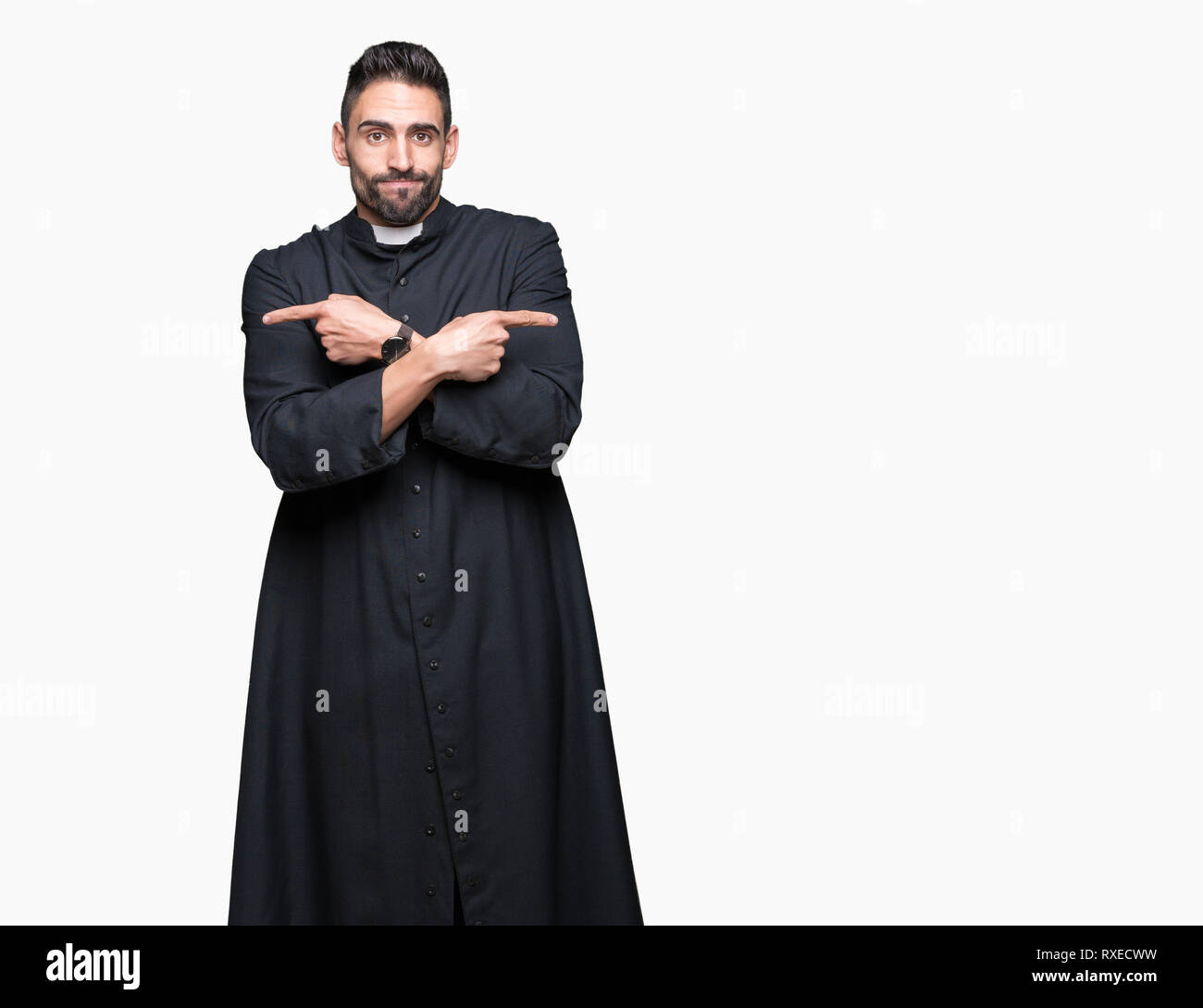 Young Christian priest over isolated background Pointing to both sides ...