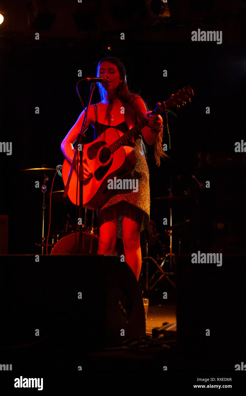 Female singer with acoustic guitar playing on stage Stock Photo - Alamy