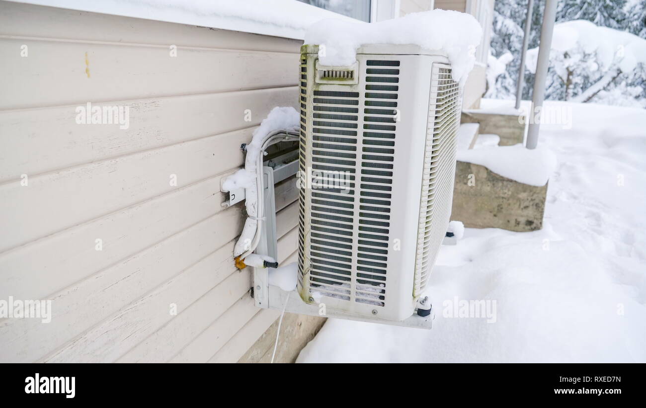 The heater attached on the wall of the house filled with snow during ...