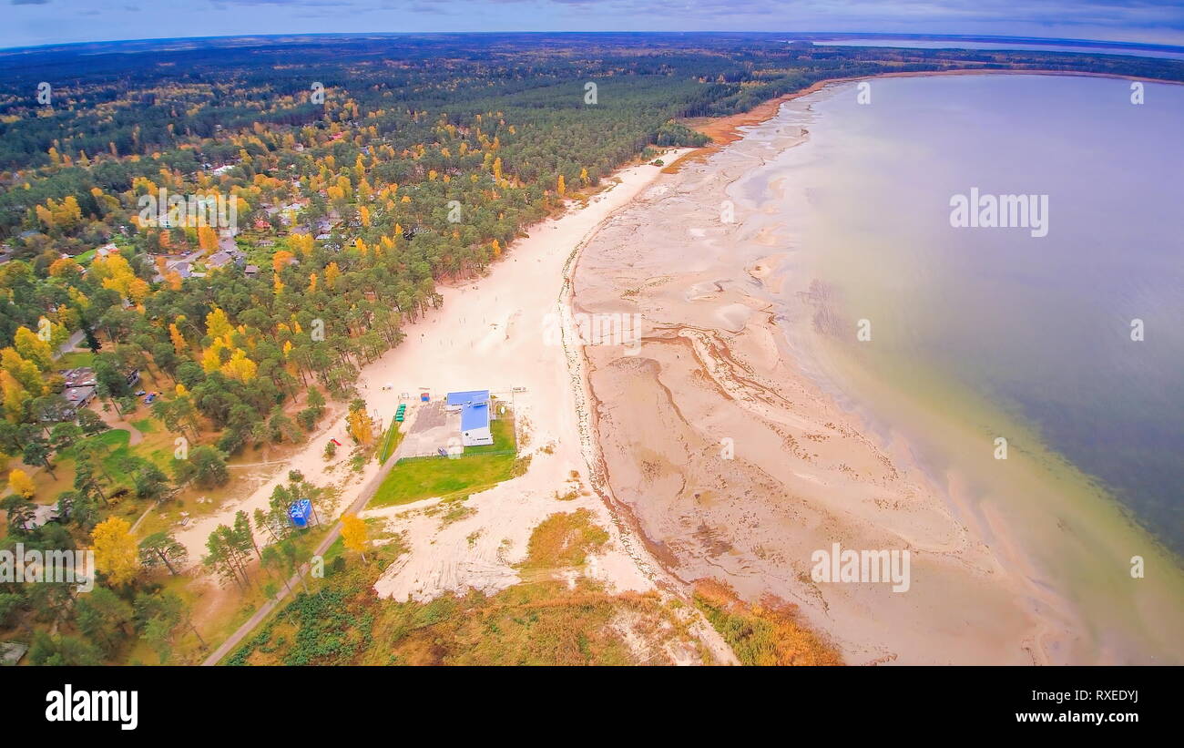 The wide white beach coastline of Vosu with lots of trees fronting the ...
