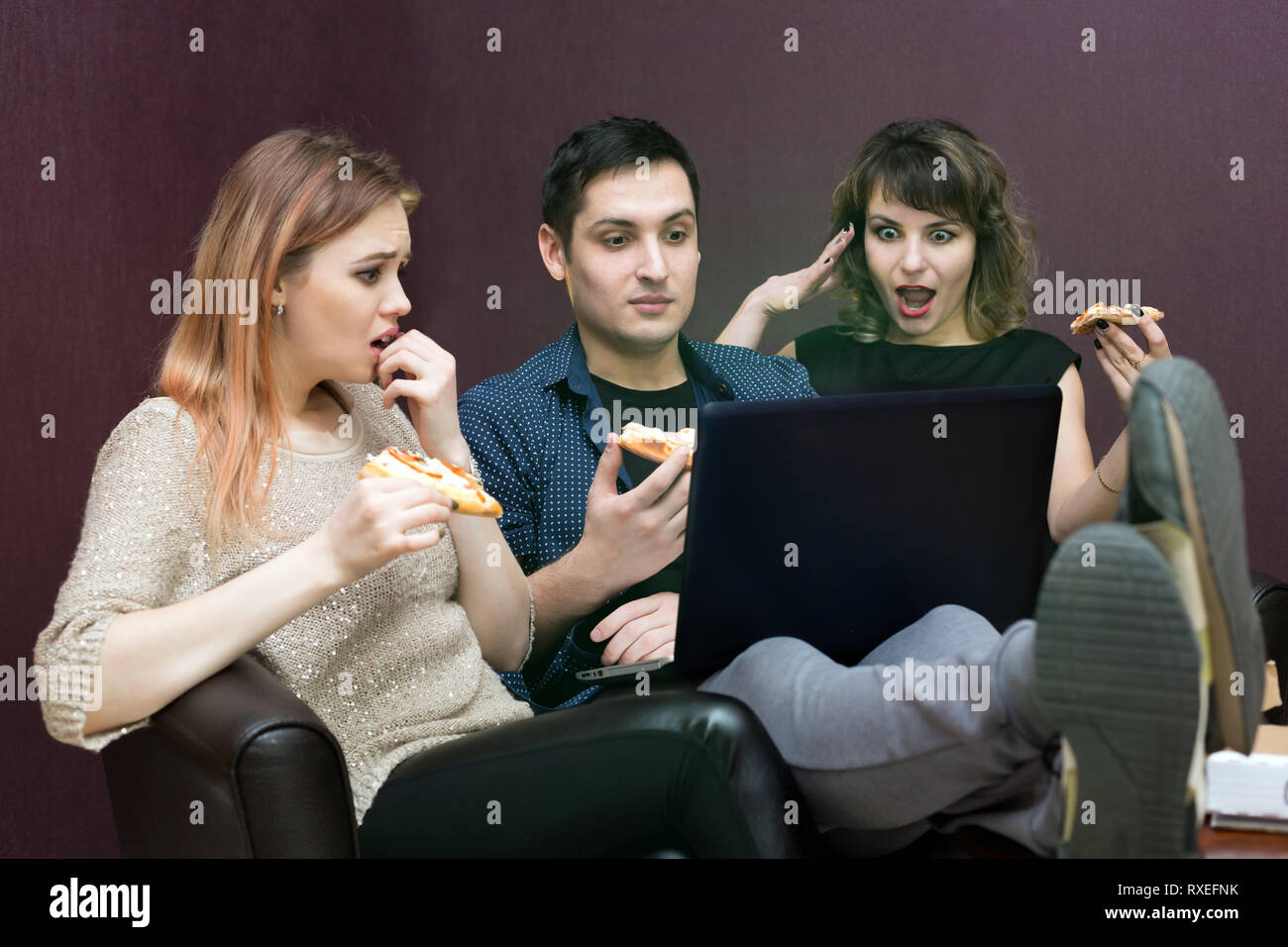 A man and two women are watching a movie on a computer Stock Photo - Alamy