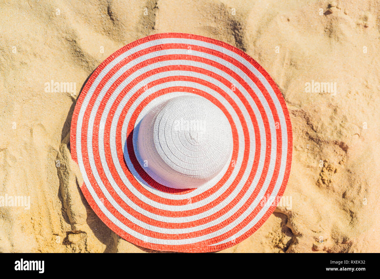 Top view of sandy beach with red striped beach hat Background with copy ...