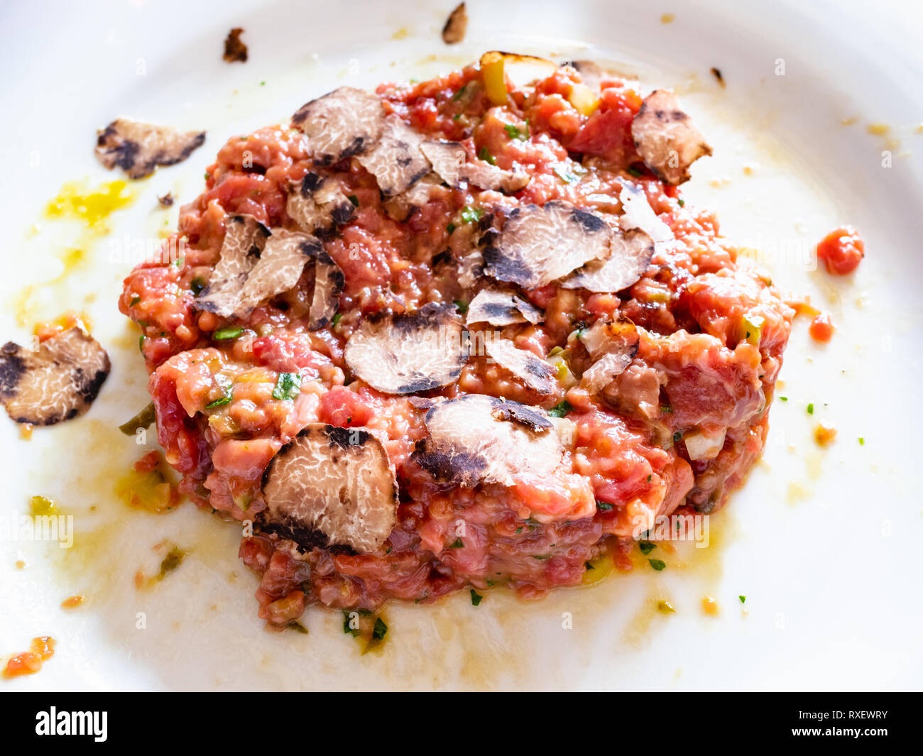 beef steak tartare with raw egg and truffle close up on white plate in ...