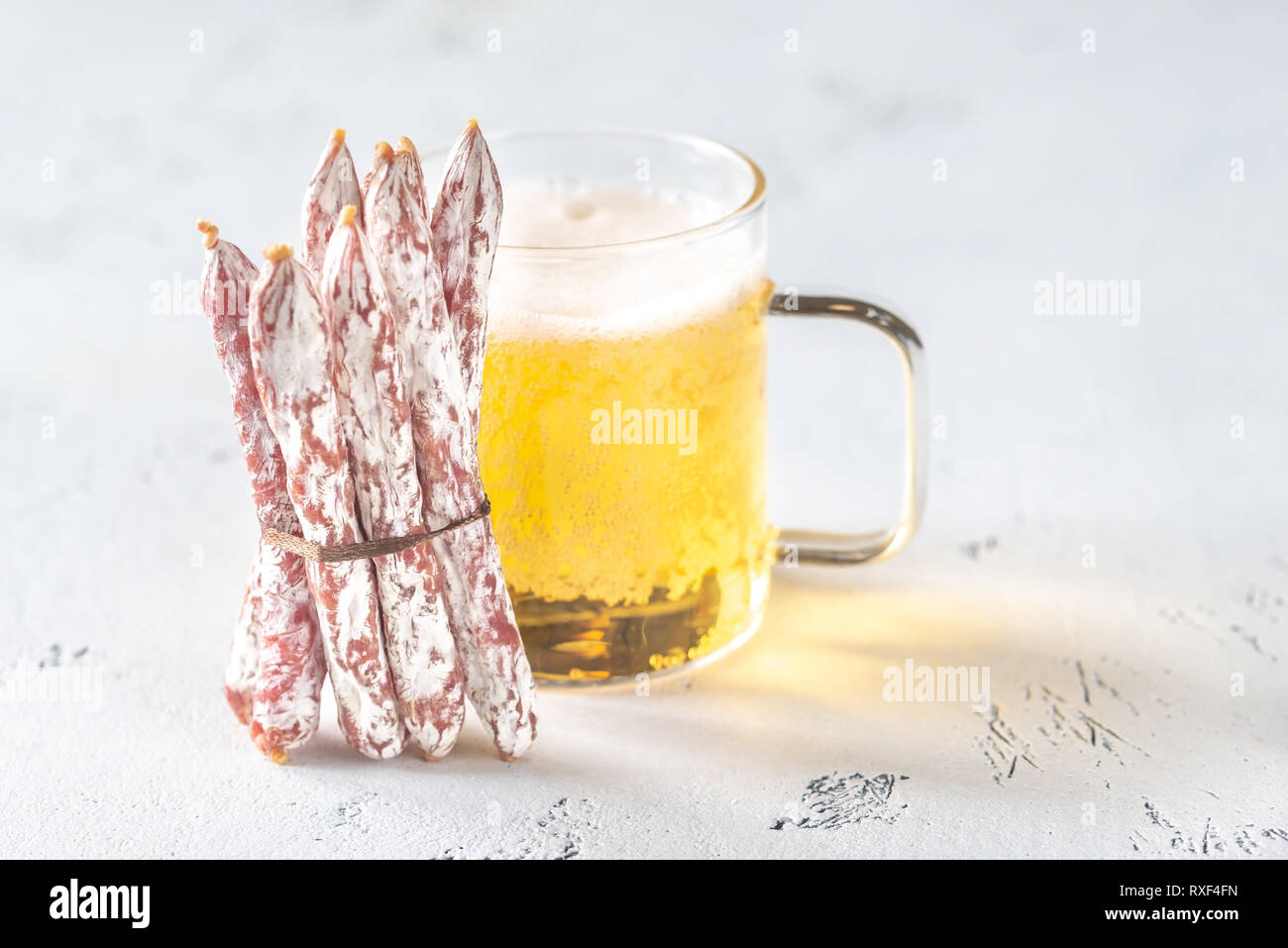 Snack fuet sausages with glass mug of beer Stock Photo - Alamy
