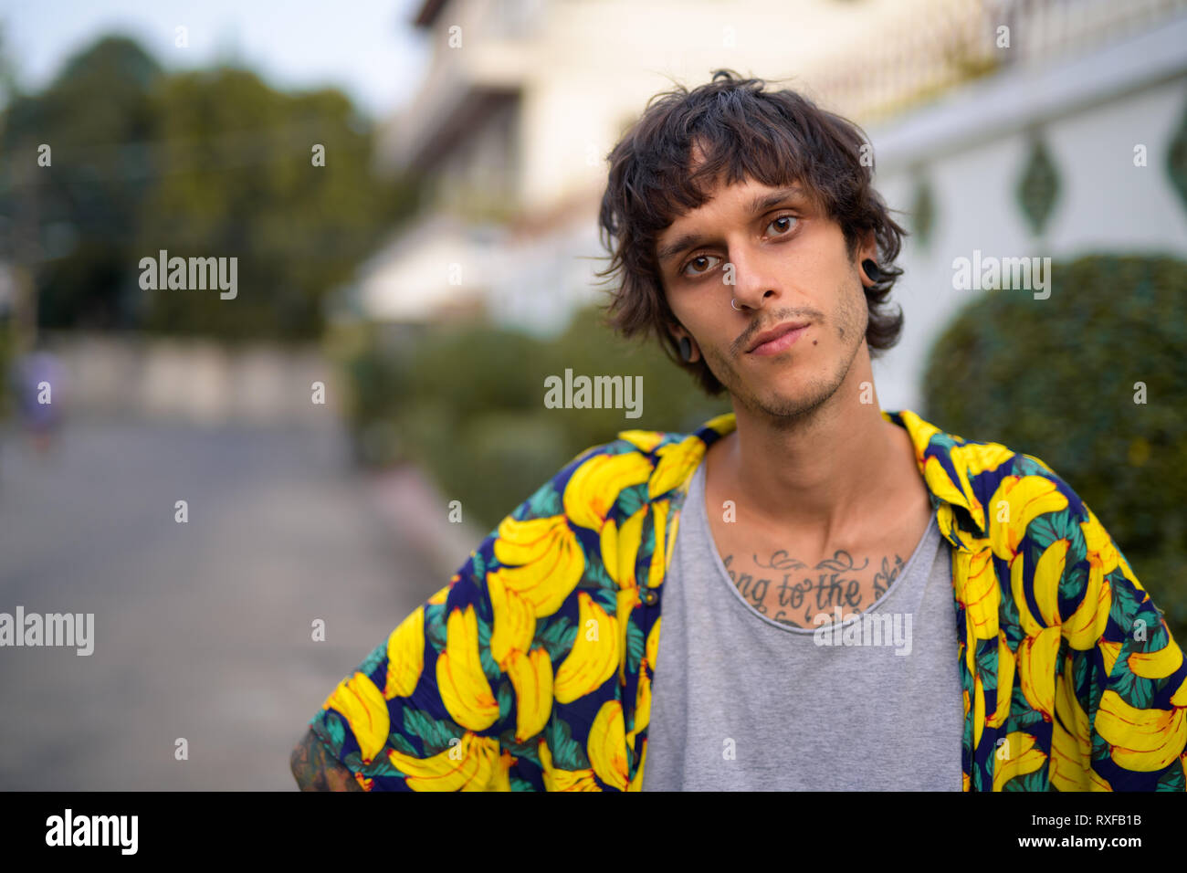 Face of young rebellious man standing on the sidewalk outdoors Stock ...