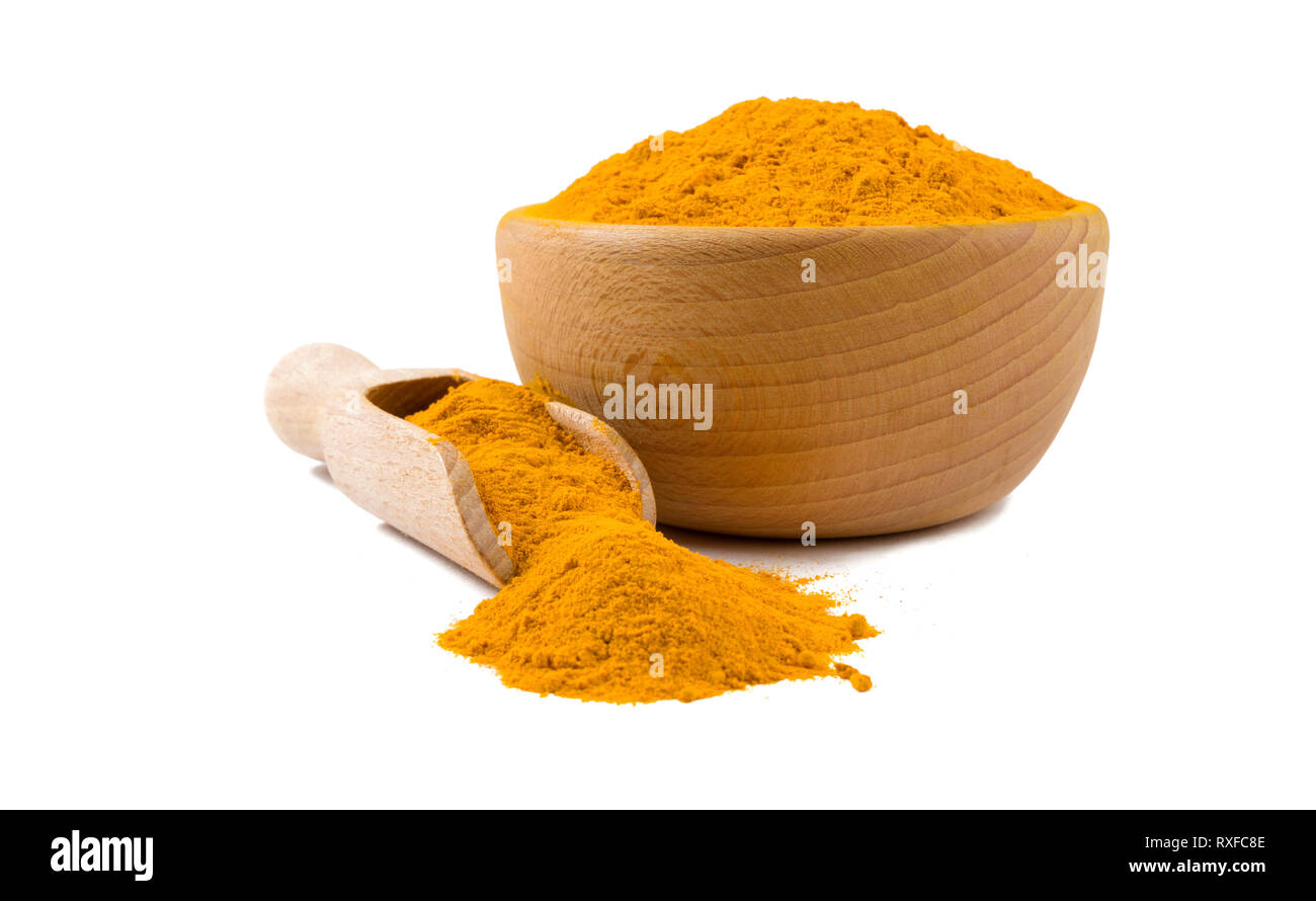 turmeric powder in wooden bowl and scoop isolated on white background ...