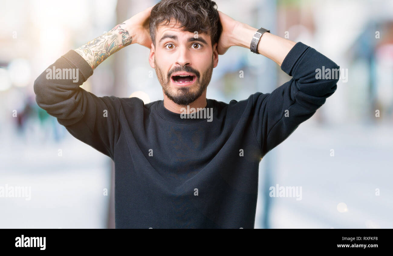 Young handsome man over isolated background Crazy and scared with hands ...