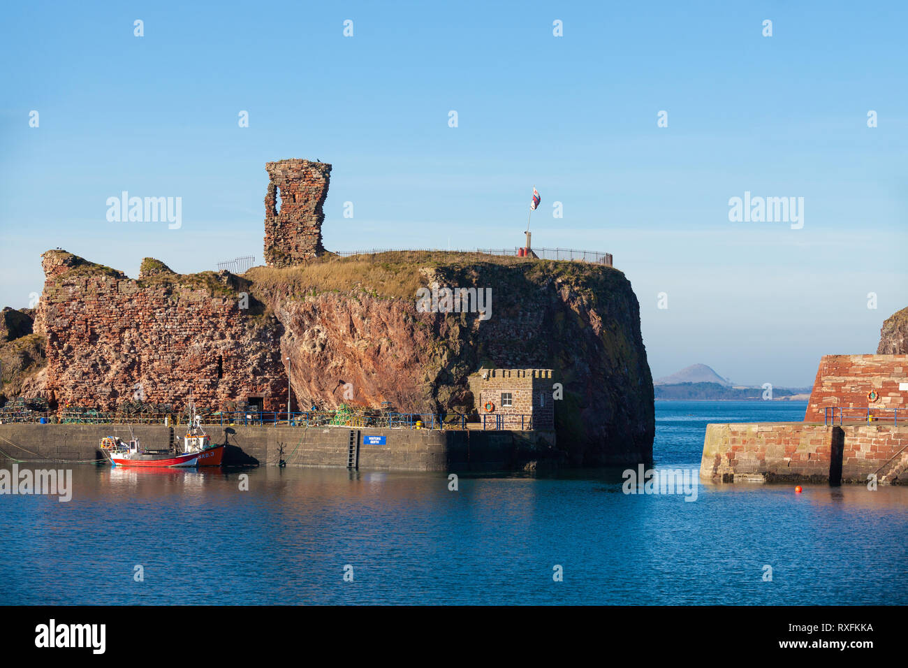 Dunbar harbour and Dunbar Castle with North Berwick Law in the ...