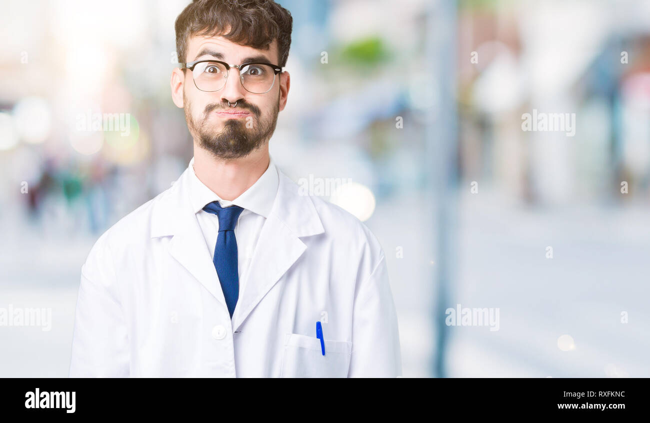 Young professional scientist man wearing white coat over isolated ...